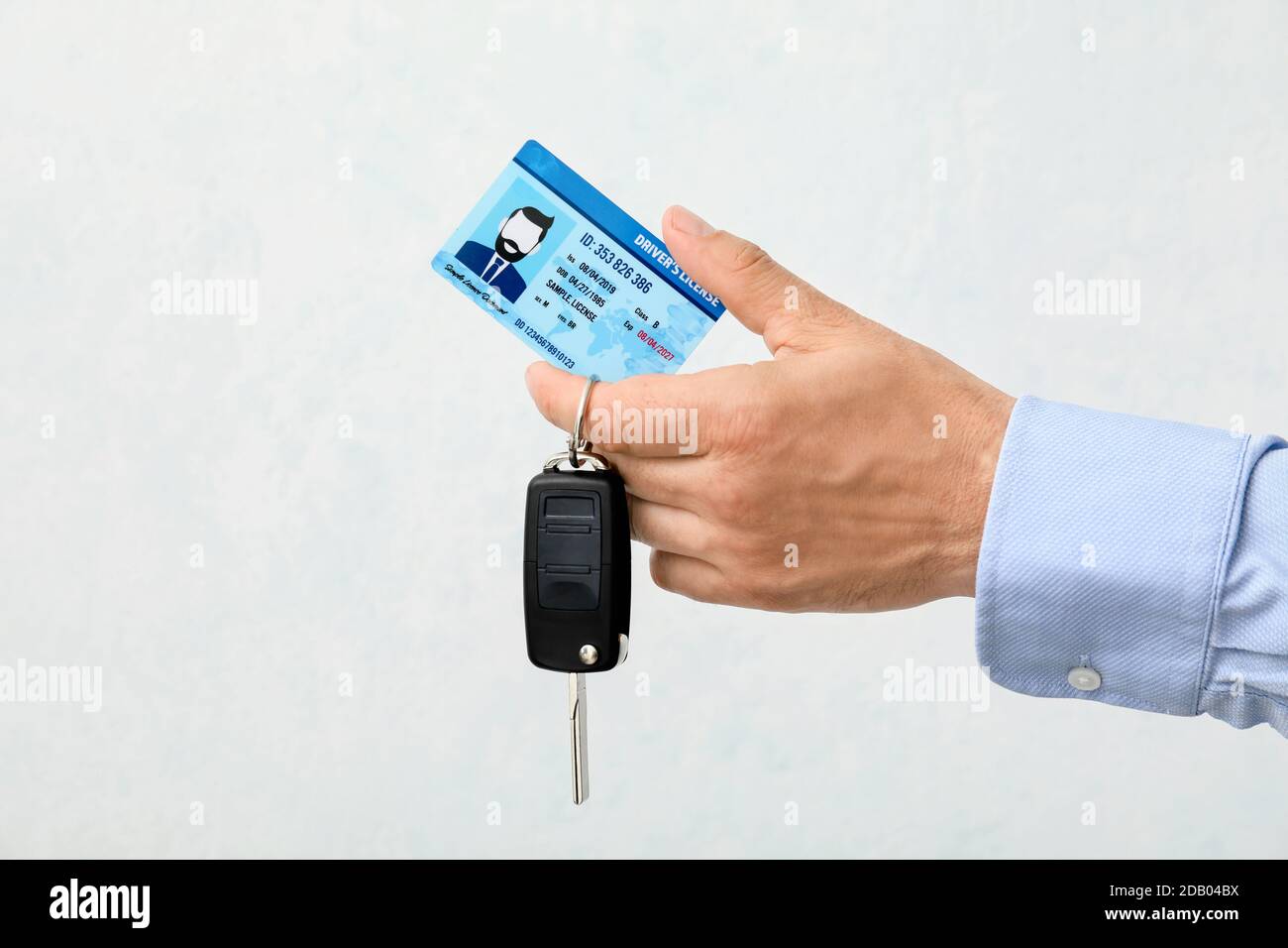 Male hand with driving license and car key on light background Stock ...