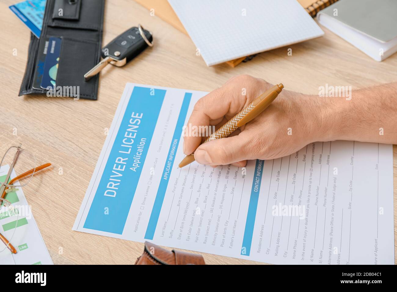 Man filling in driving license application at table Stock Photo - Alamy