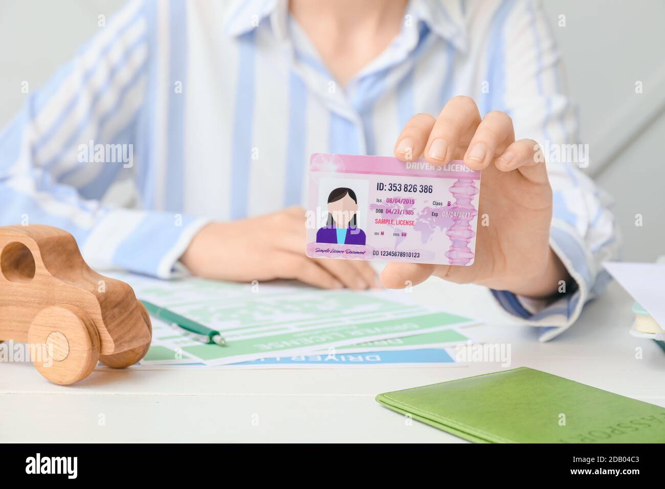 Woman with driving license and application form at table Stock Photo ...