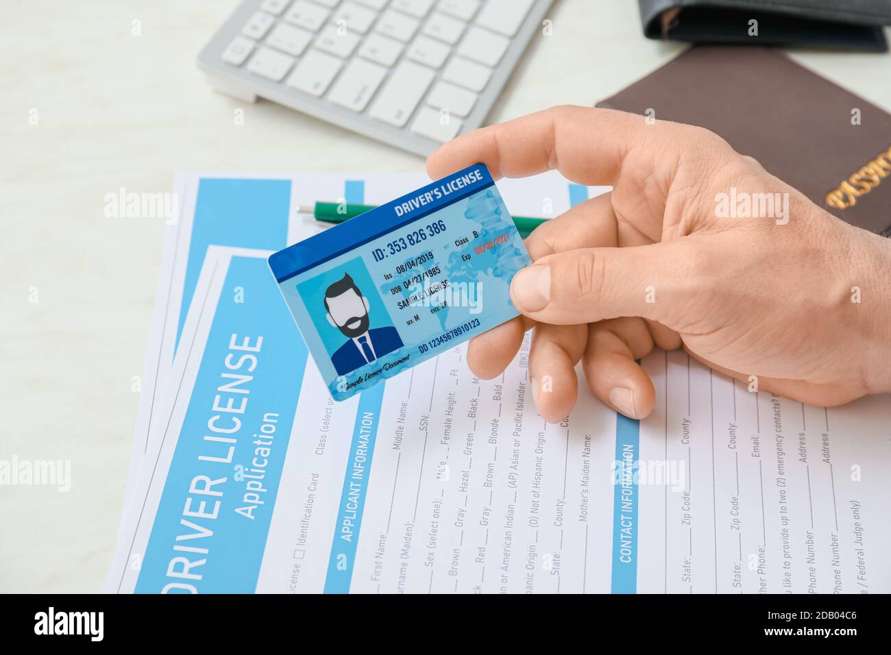 Man with driving license and application form at table Stock Photo - Alamy