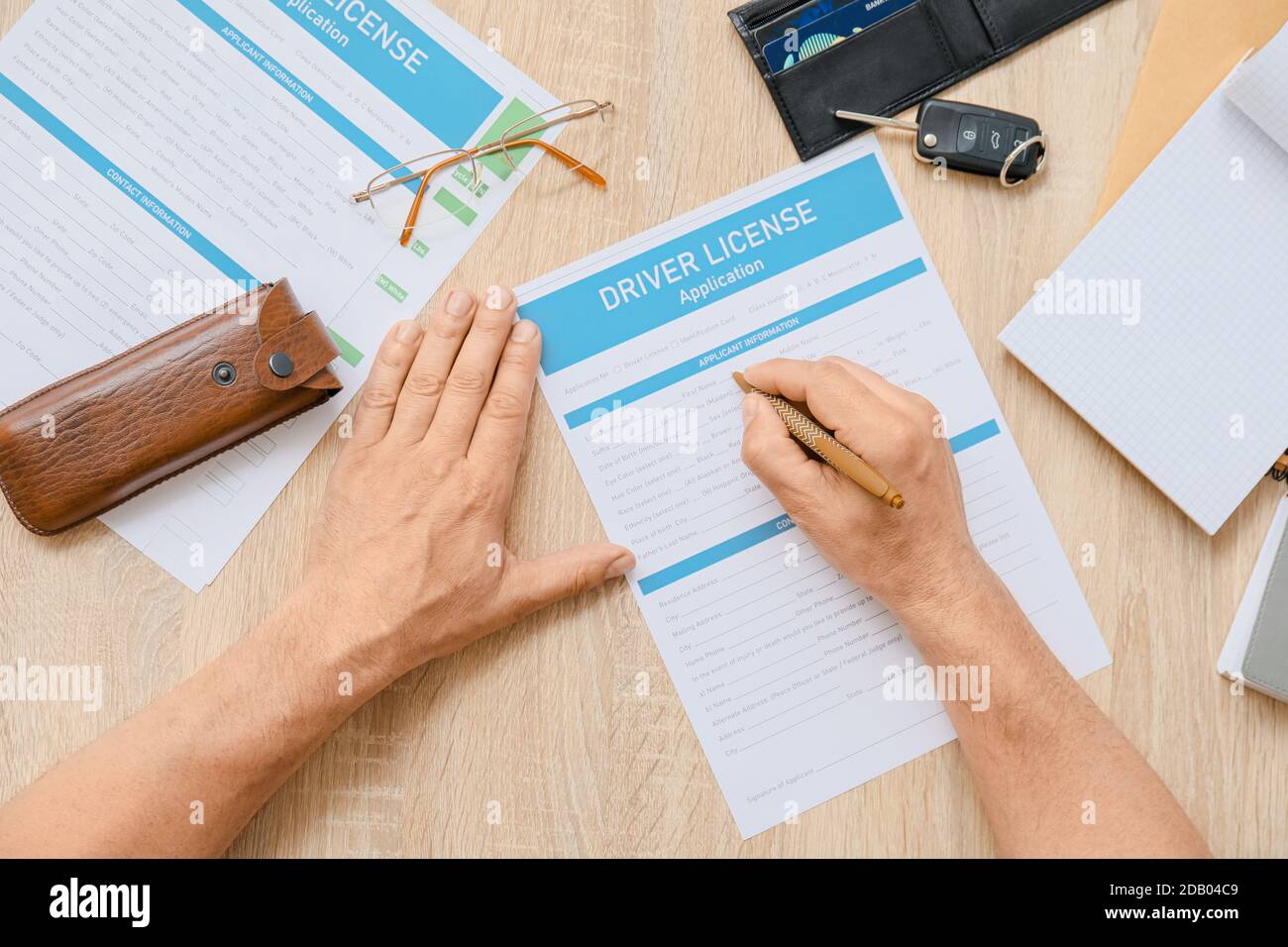 Man filling in driving license application at table Stock Photo - Alamy
