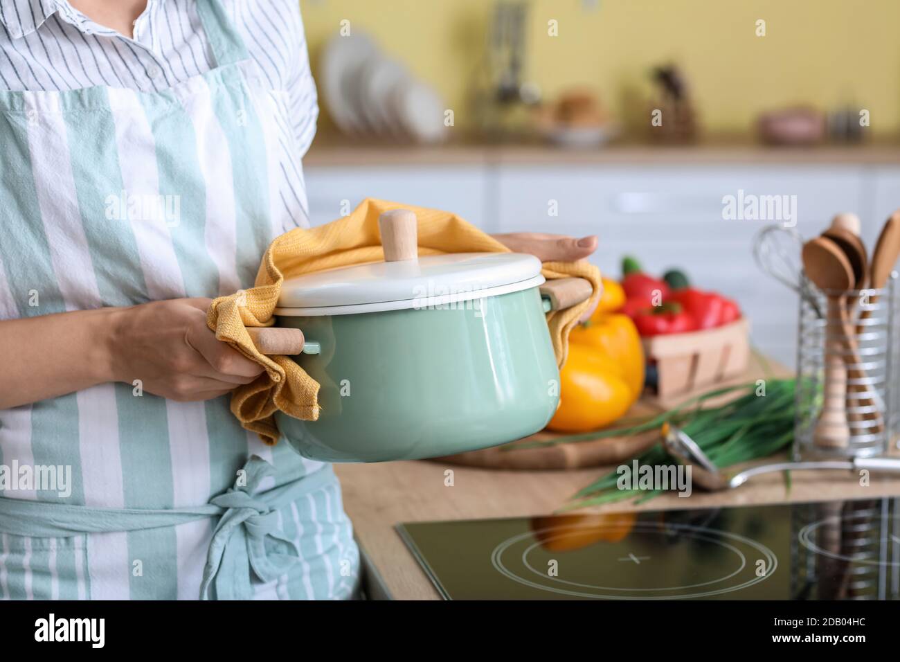 Woman with cooking pot in kitchen Stock Photo - Alamy