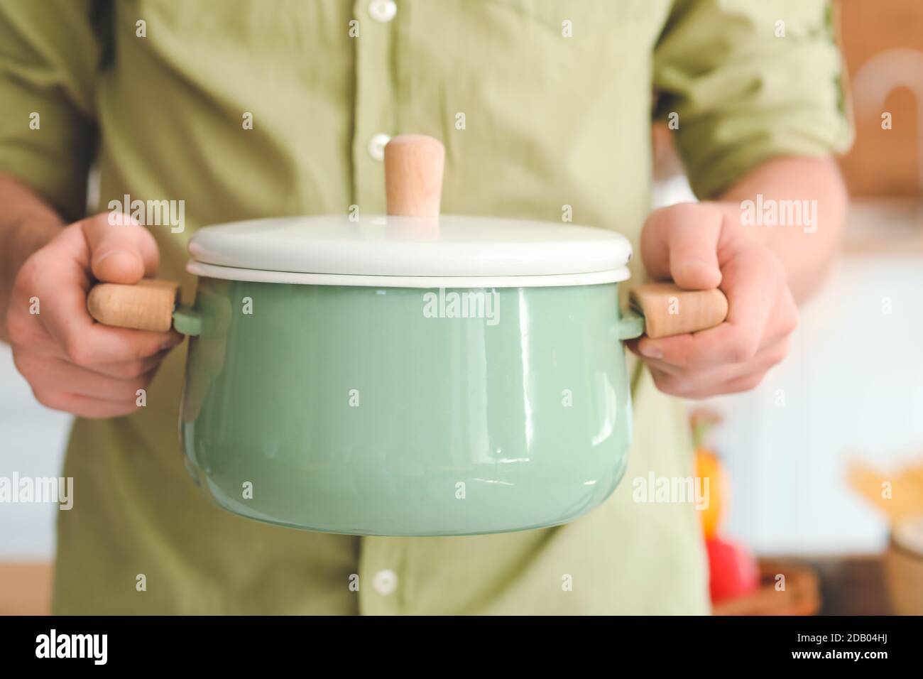 Man with cooking pot in kitchen, closeup Stock Photo - Alamy