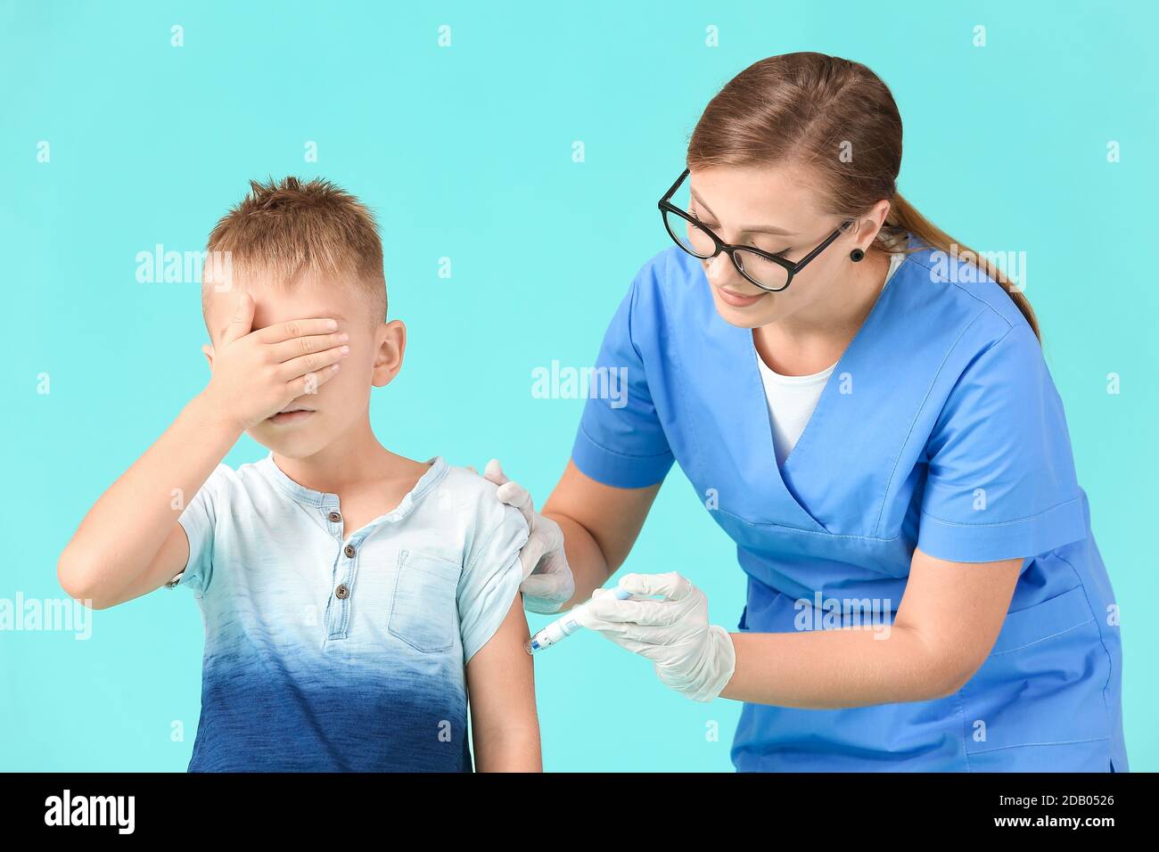 Doctor giving diabetic boy insulin injection on color background Stock ...