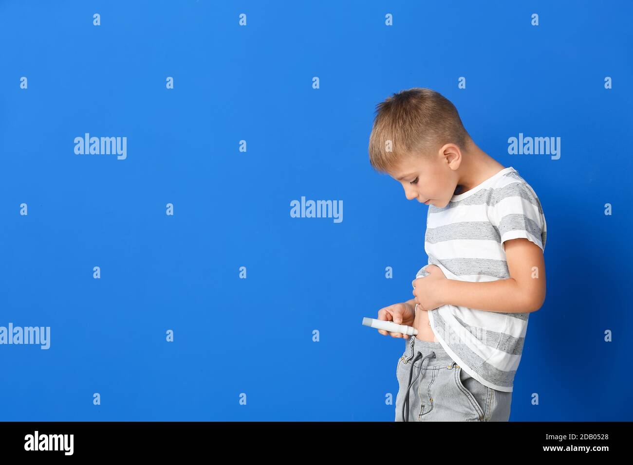 Little diabetic boy giving himself insulin injection on color ...