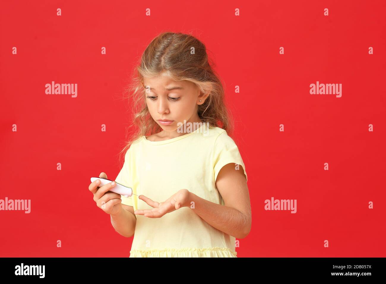 Little diabetic girl with glucometer on color background Stock Photo ...