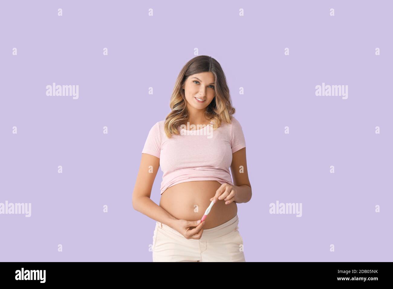 Beautiful pregnant woman with test on color background Stock Photo - Alamy