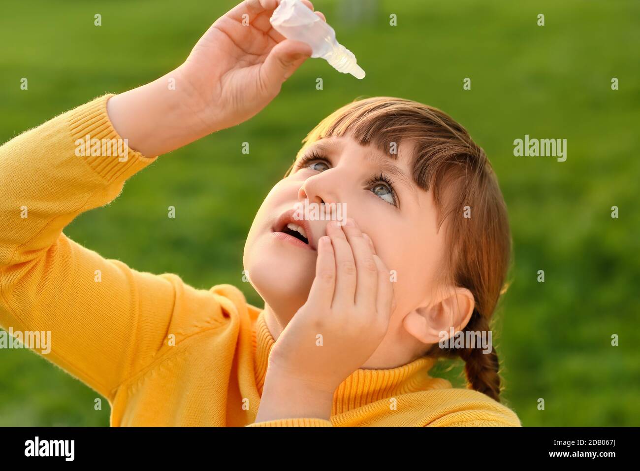 Little allergic girl using eye drops outdoors Stock Photo - Alamy