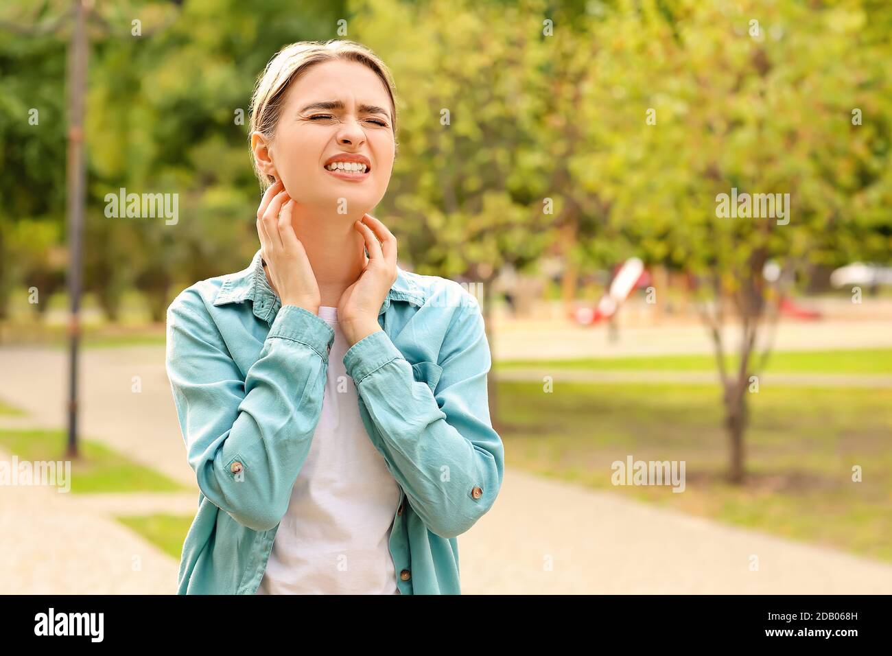 Allergic young woman scratching herself outdoors Stock Photo - Alamy