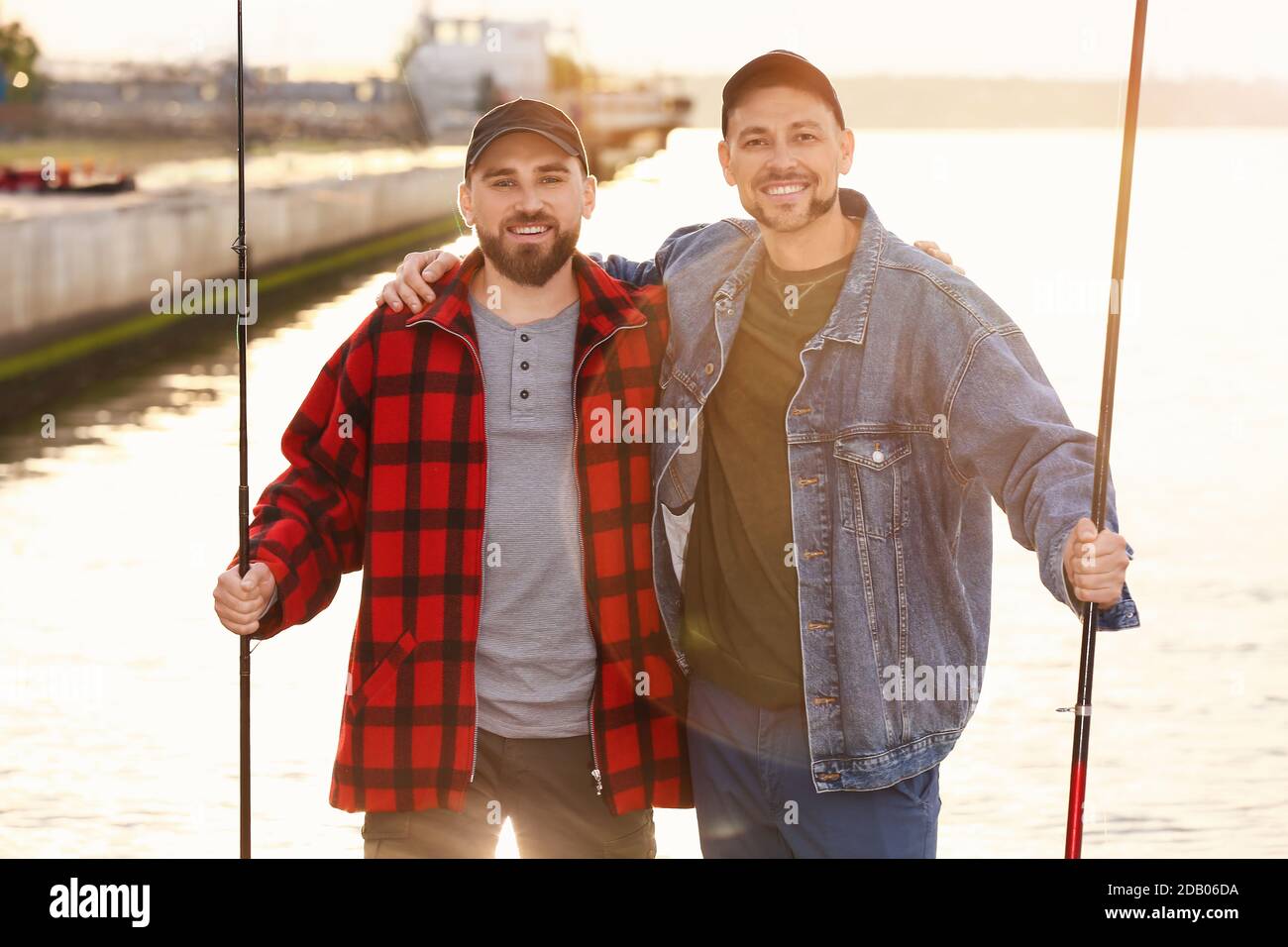Happy young men fishing on river Stock Photo - Alamy