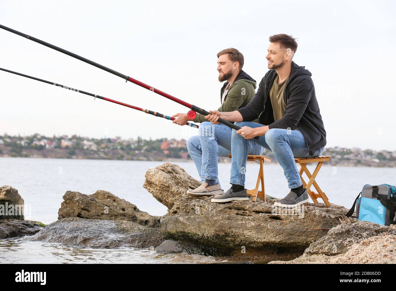 Young men fishing on river Stock Photo - Alamy