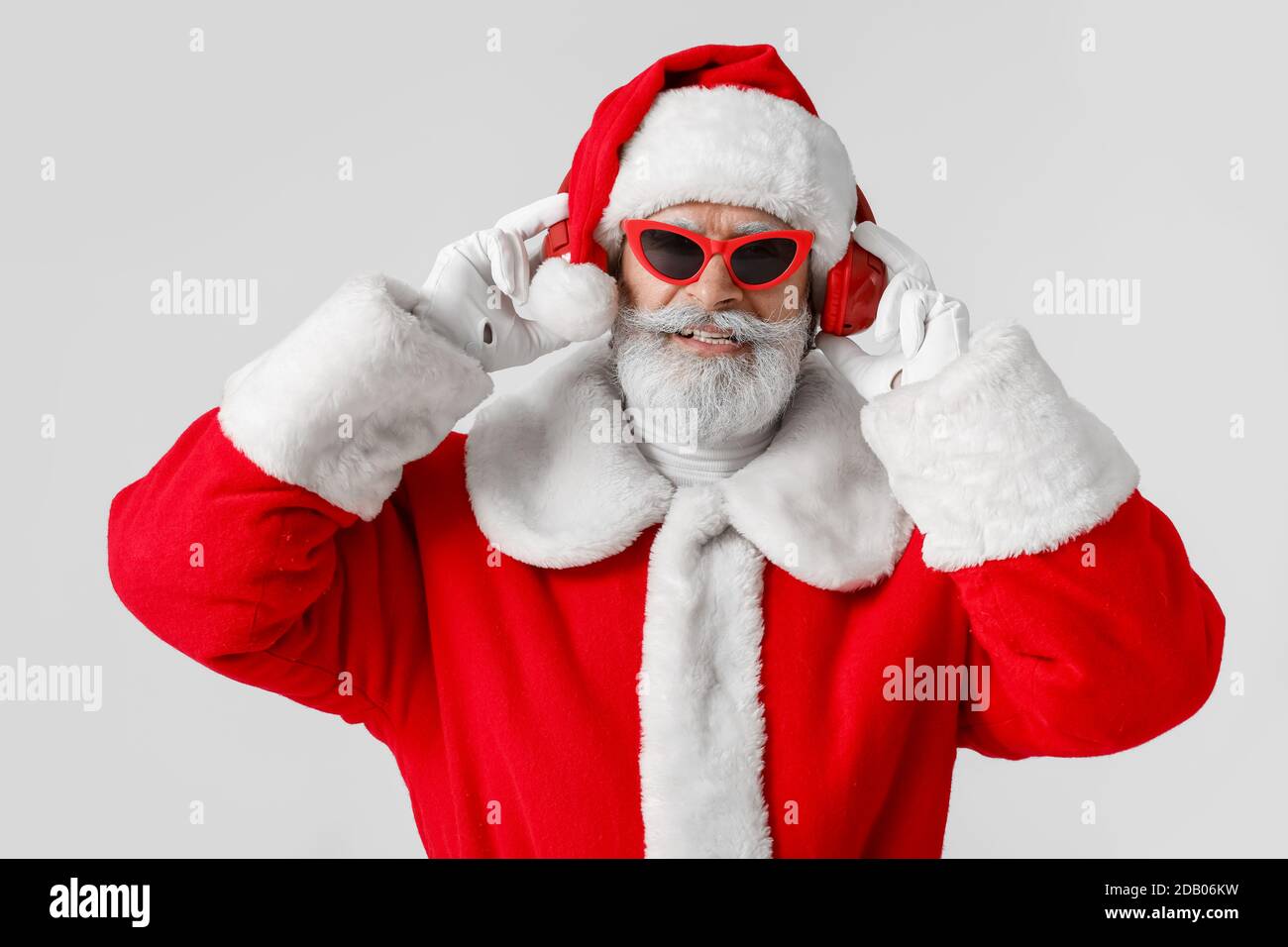 Cool Santa Claus listening to music on grey background Stock Photo - Alamy