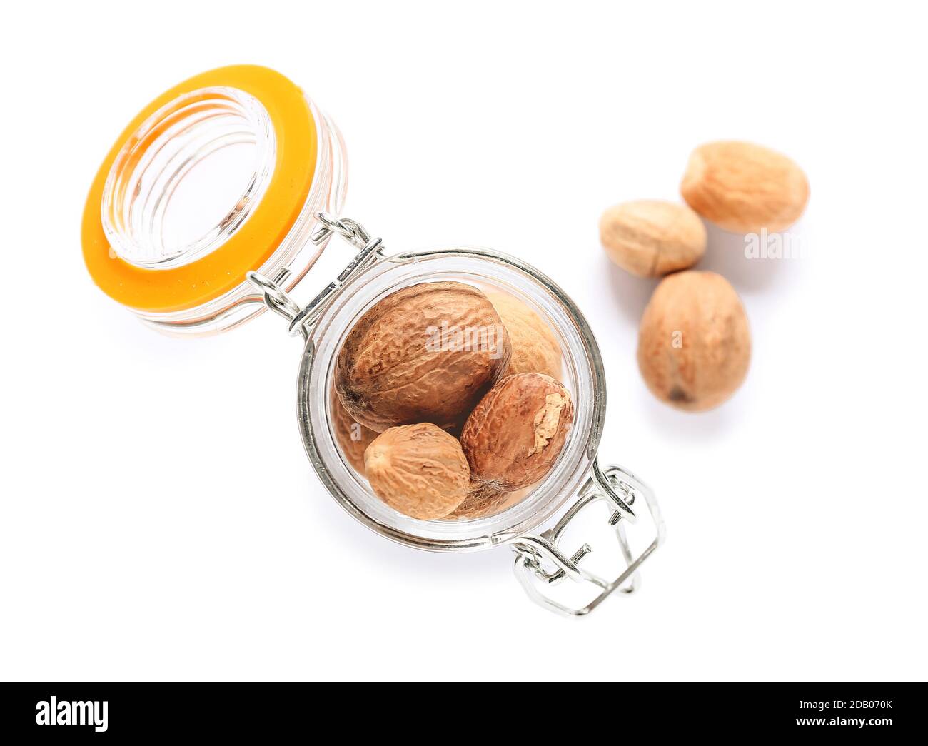 Jar with nutmeg on white background Stock Photo - Alamy
