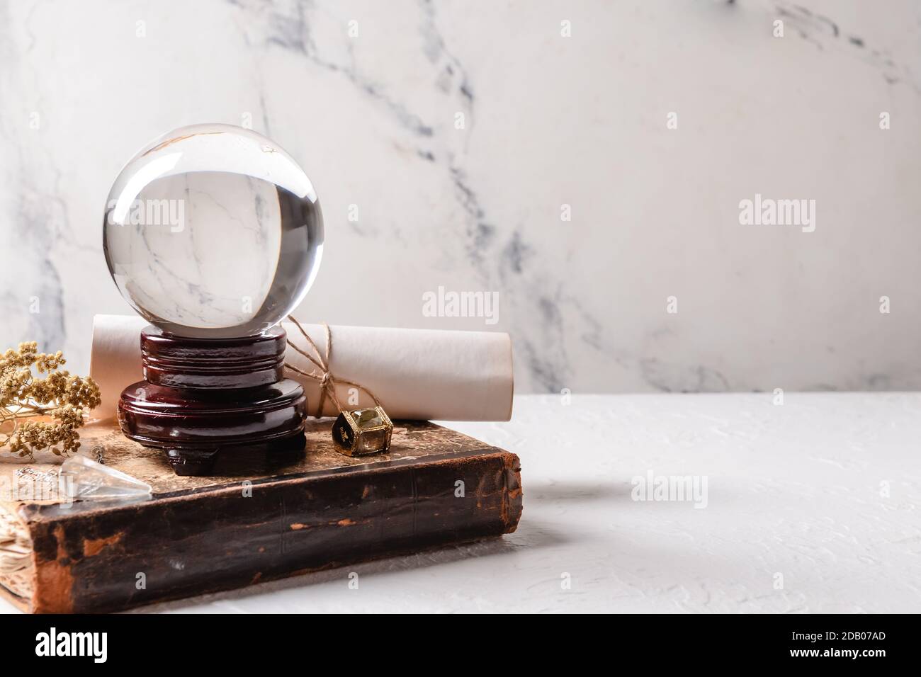 Crystal ball of fortune teller, spell book and scroll on table Stock ...