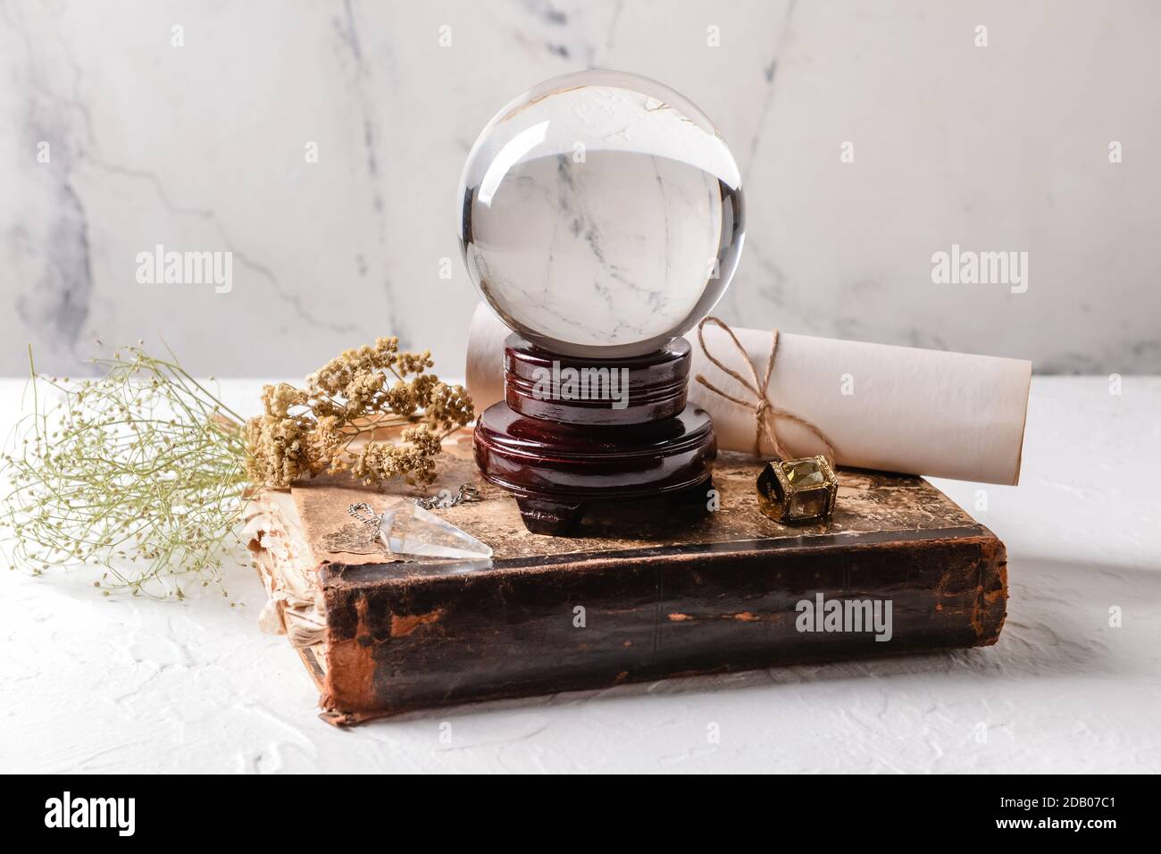 Crystal ball of fortune teller, spell book and scroll on table Stock ...