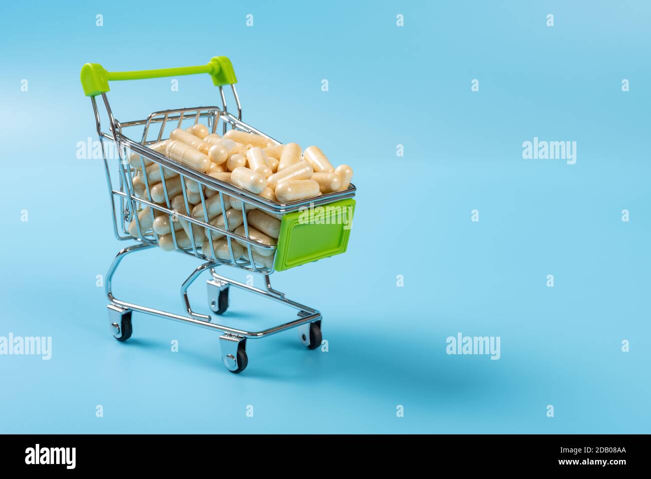 side view shopping cart full filled with capsules on blue background ...