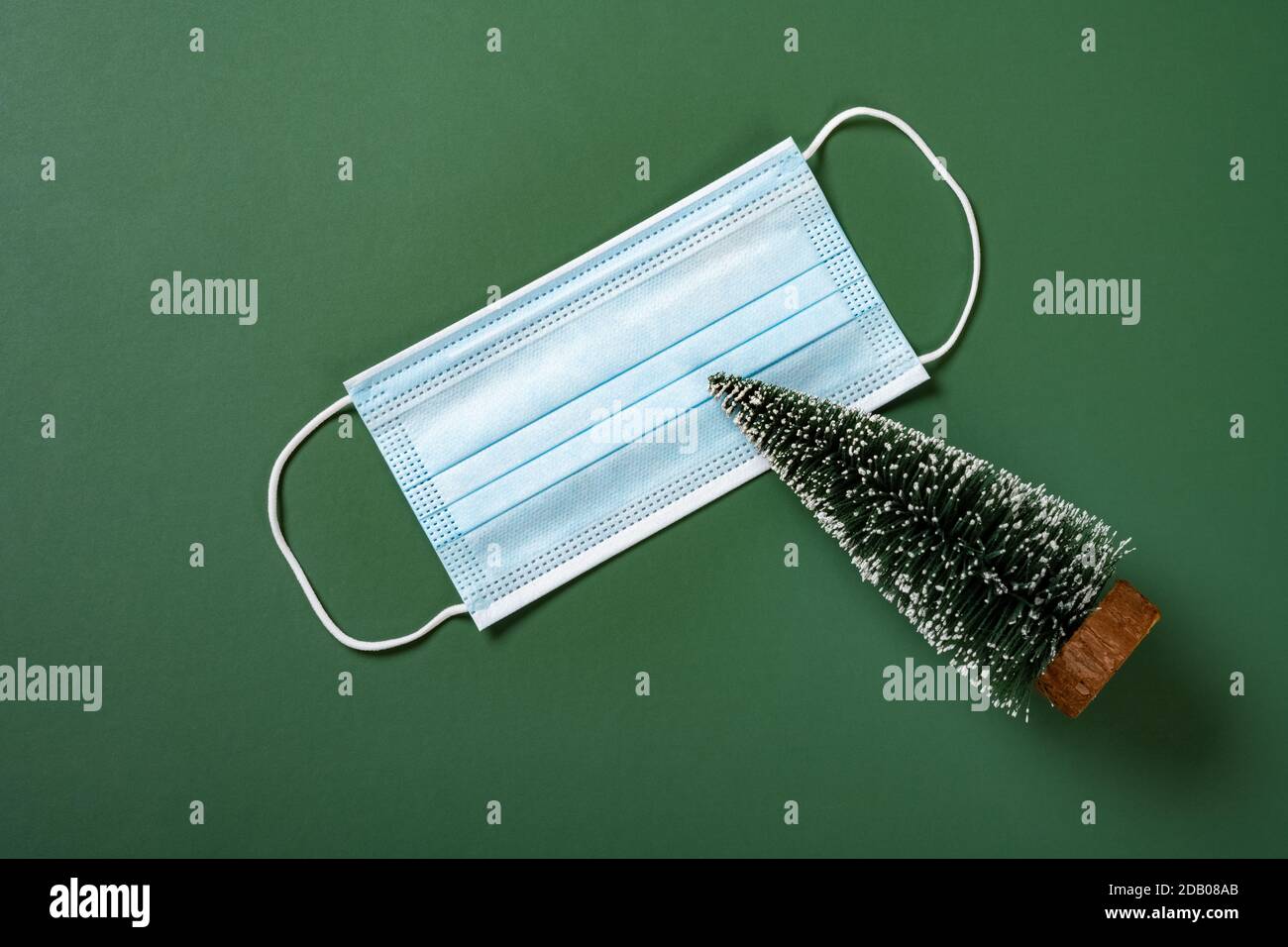 medical mask with Christmas tree on top over green background Stock ...