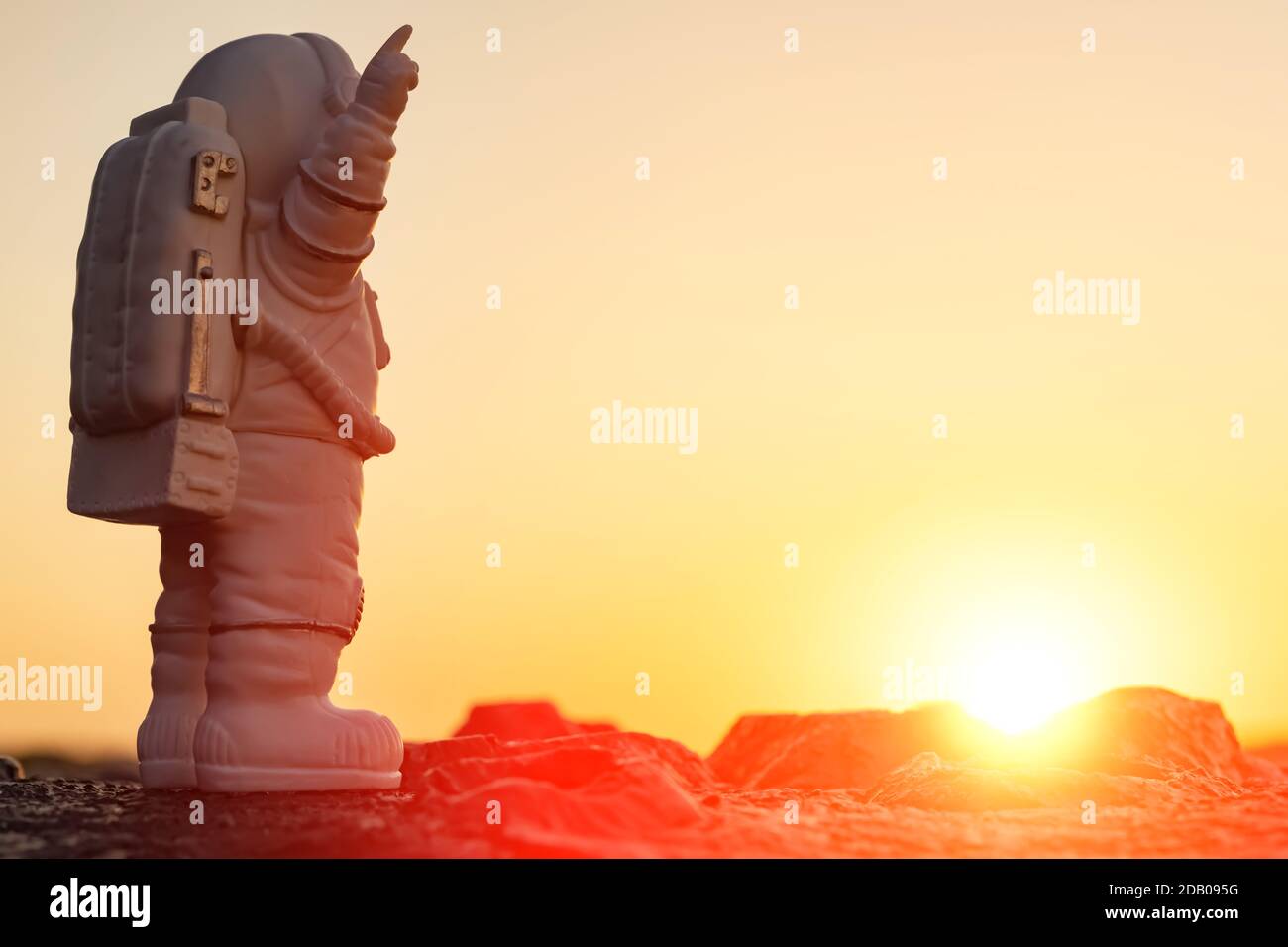 astronaut standing on a planet with the finger pointing up and looking ...