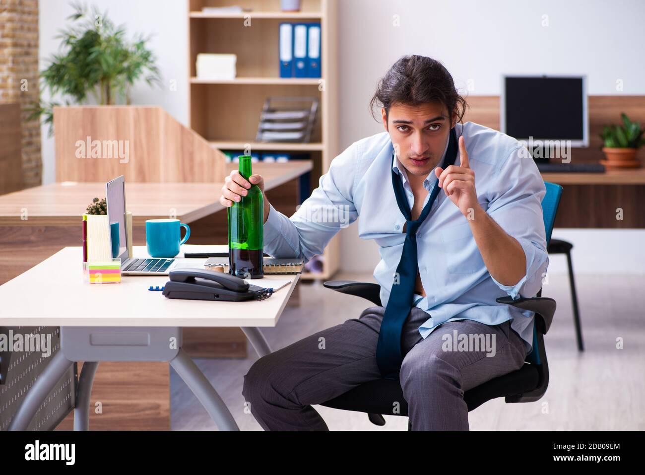 Male employee drinking alcohol at workplace Stock Photo - Alamy
