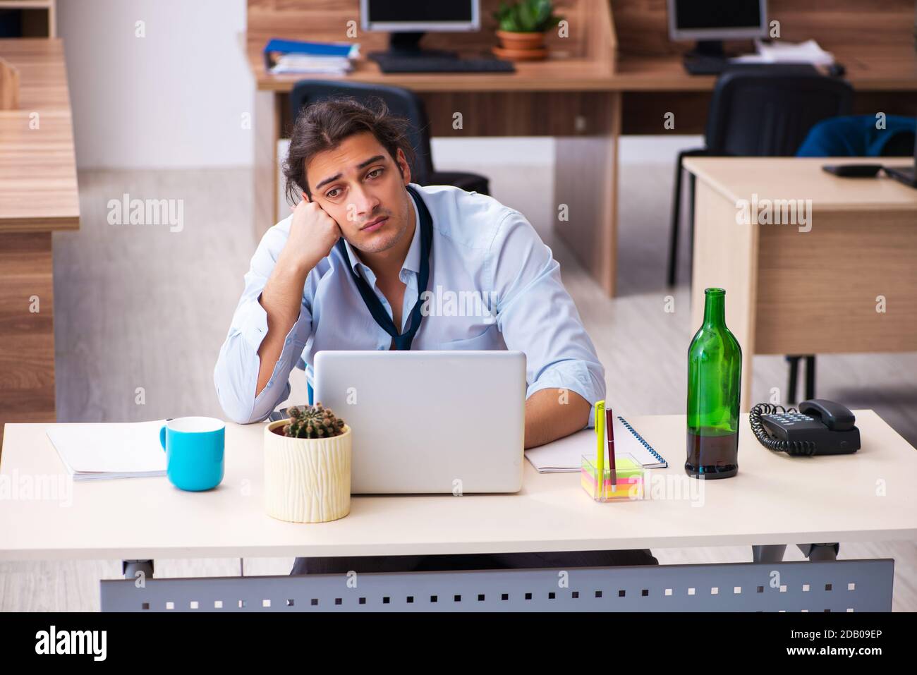 Male employee drinking alcohol at workplace Stock Photo - Alamy