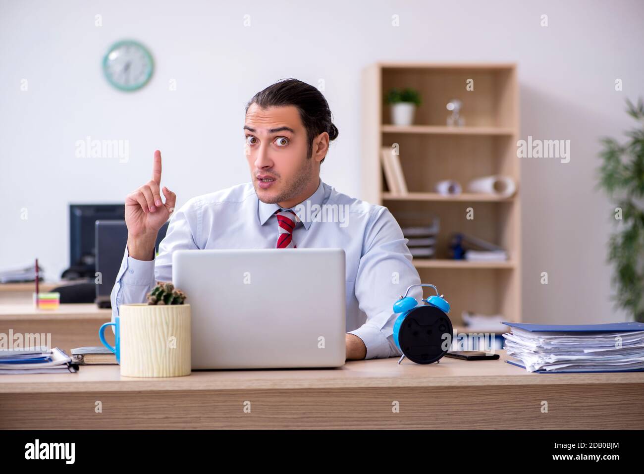 Male employee in time management concept Stock Photo - Alamy