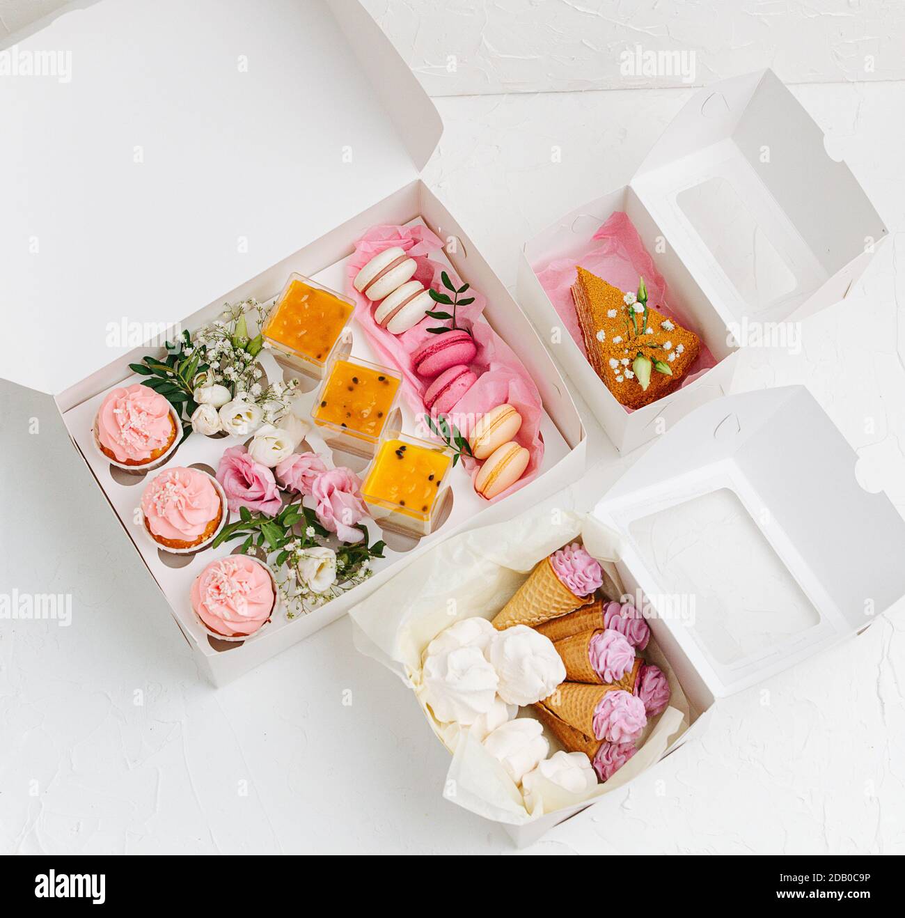 Colorful tasty sweets in opened white windowed boxes. Top view Stock ...