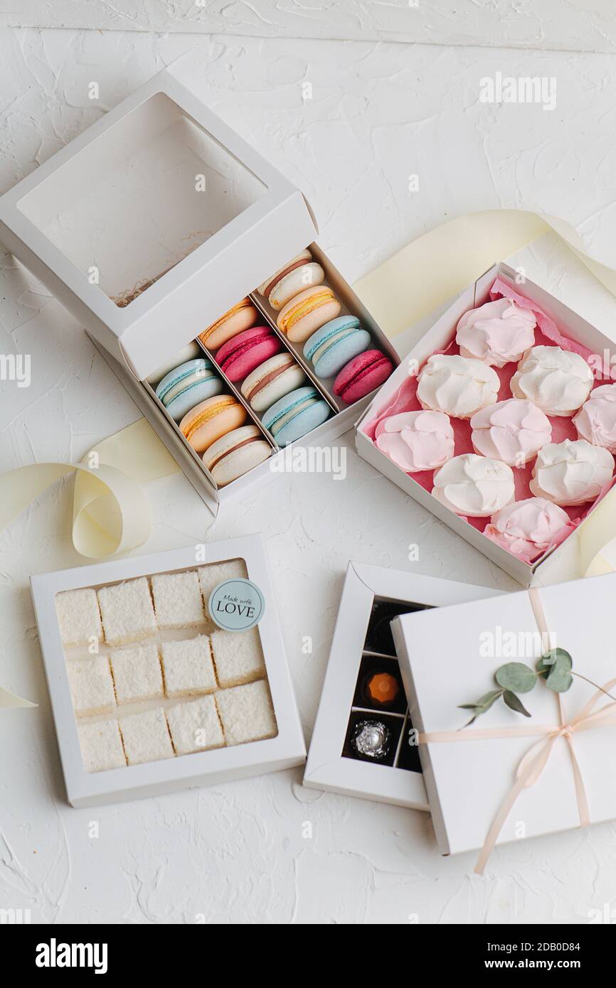 Lots of sweets in square boxes. Macarons, turkish delight, zefir ...