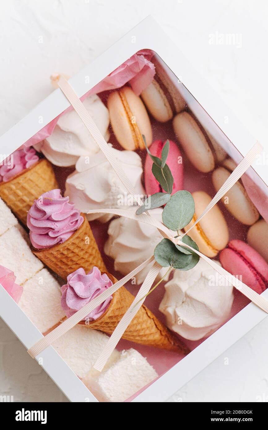 Variety of sweets in a box laid in vertical rows in a white windowed ...
