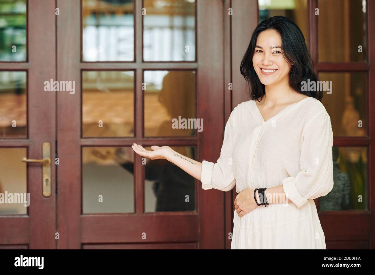 Estate agent inviting inside building Stock Photo - Alamy
