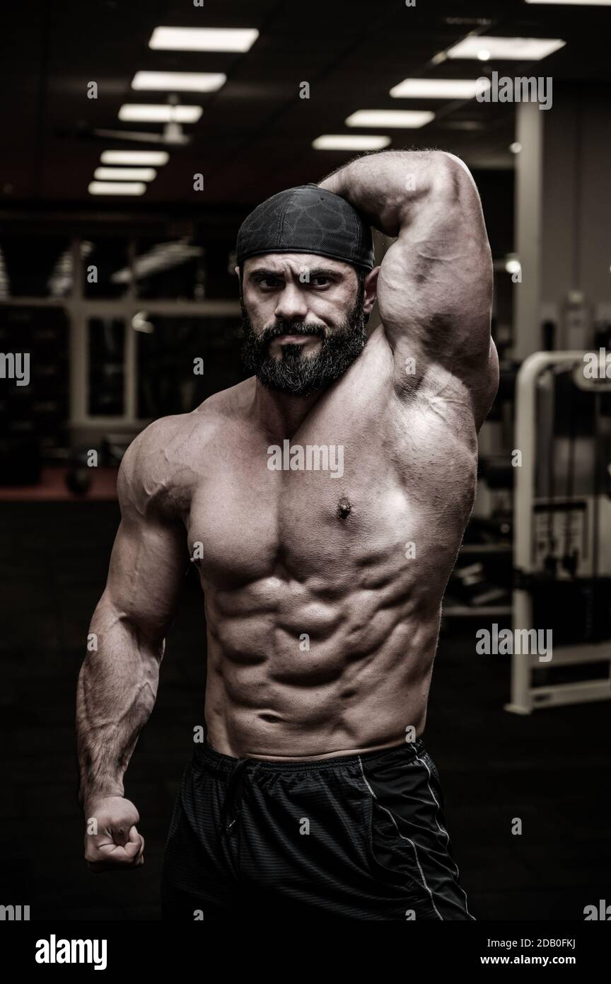 angry strong man in bandana showing abdominal and oblique muscle in ...