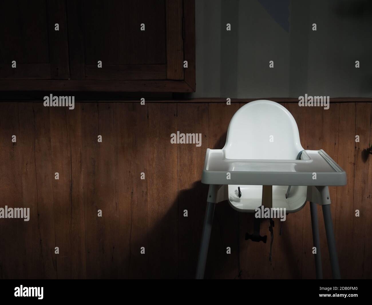 Empty lonely old white dining chair for children on wooden background ...