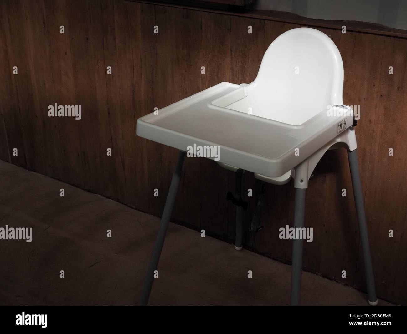 Empty lonely old white dining chair for children on wooden background ...