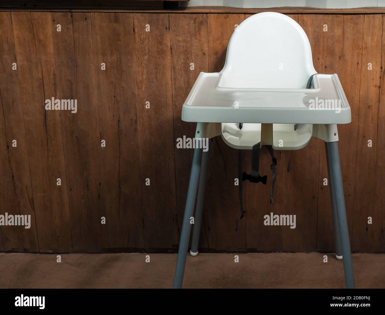 Empty lonely old white dining chair for children on wooden background ...