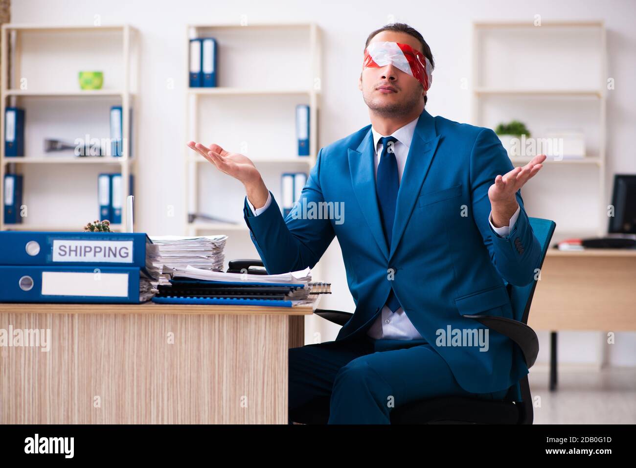 Blindfolded employee working in the office Stock Photo - Alamy