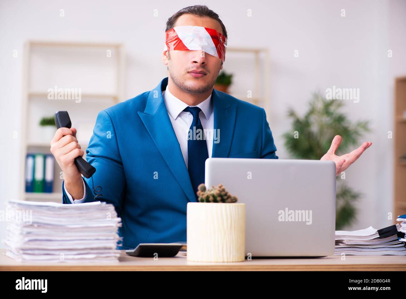 Blindfolded employee working in the office Stock Photo - Alamy