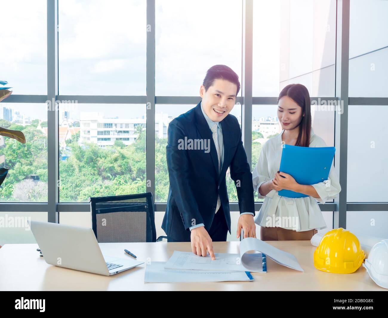 Asian male chief architect or engineer in suit and young female ...