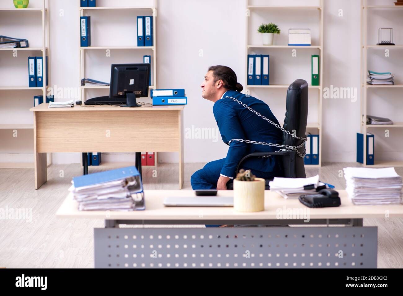 Chained employee working in the office Stock Photo - Alamy