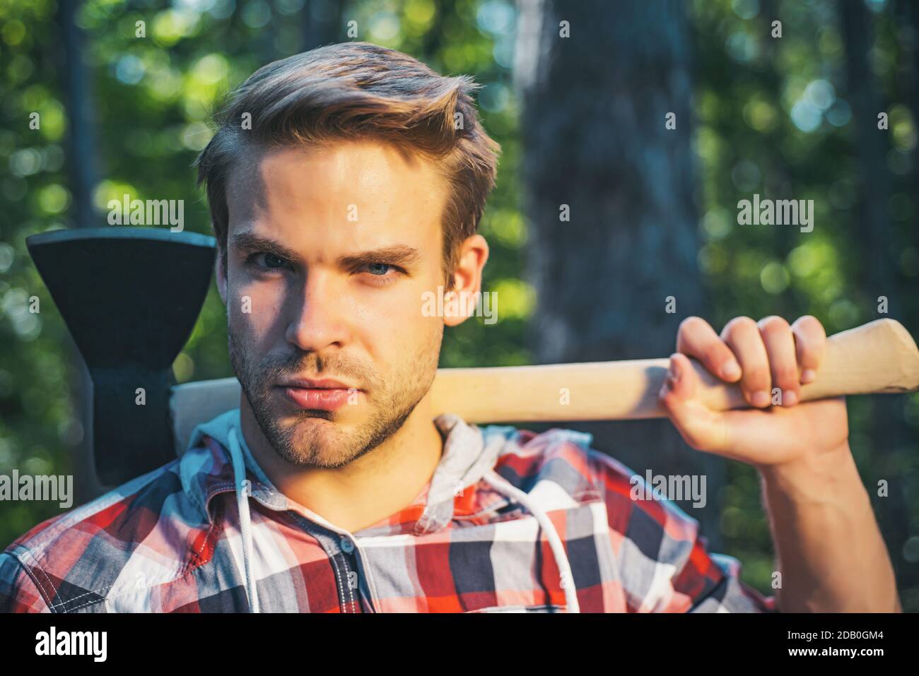 Lumberjack with ax in his hands. Handsome young man with axe near ...