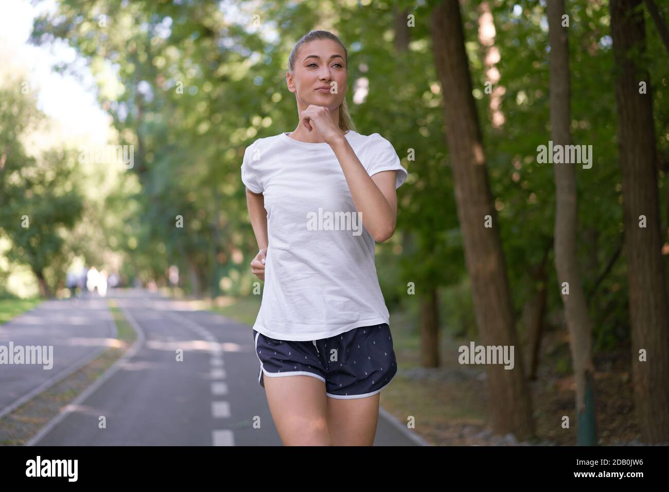 Woman running asphalt road summer park Active sporty caucasian female ...