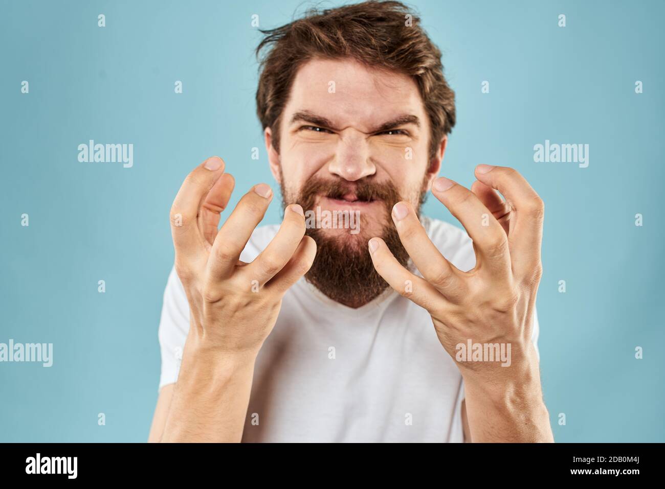 Man with disgruntled facial expression gesturing with hands studio ...