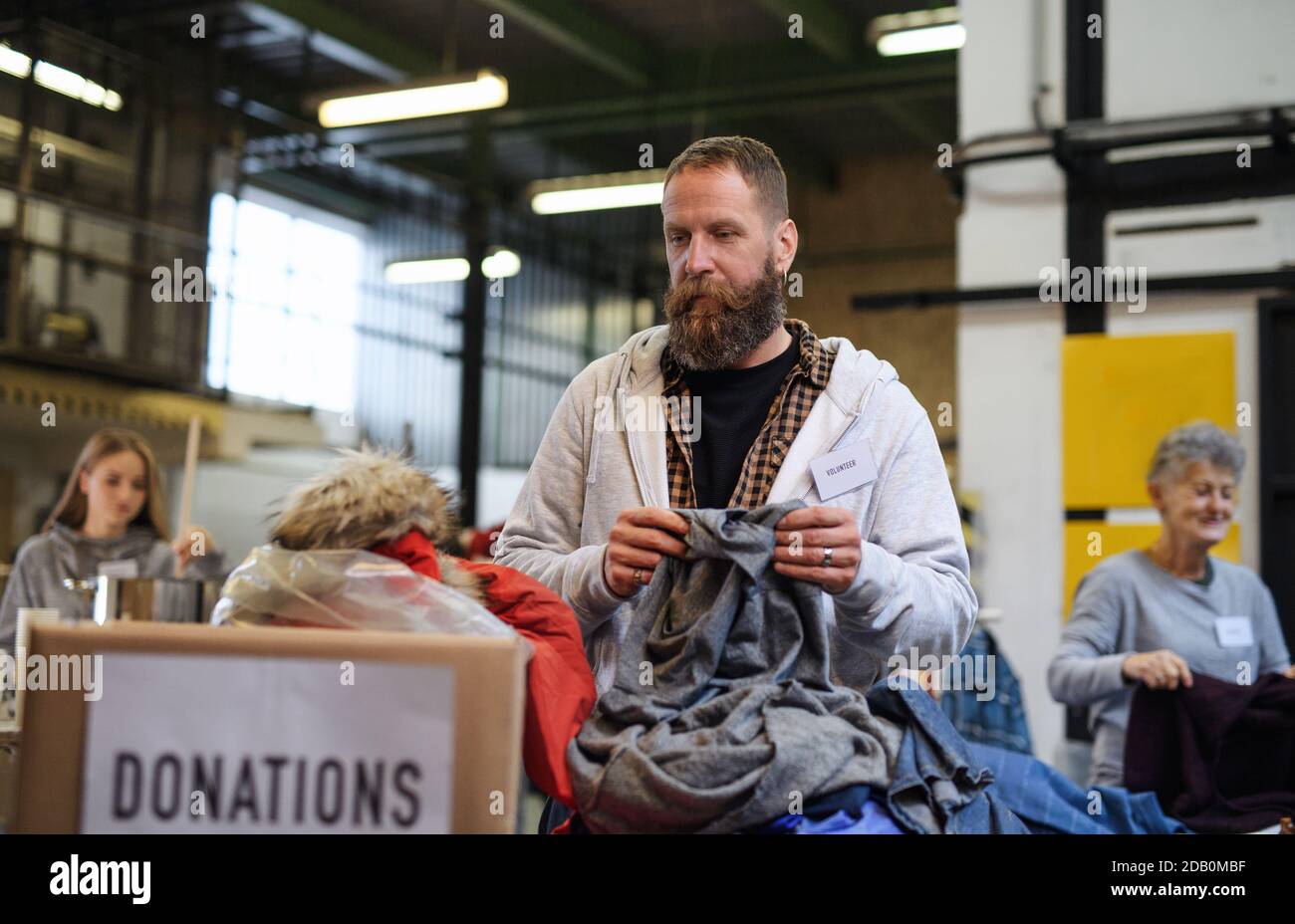 Volunteers sorting out donated clothes in community charity donation ...