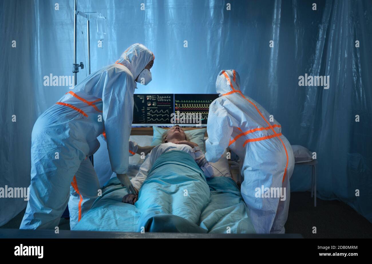 Doctors and covid-19 infected patient in bed in hospital, coronavirus ...