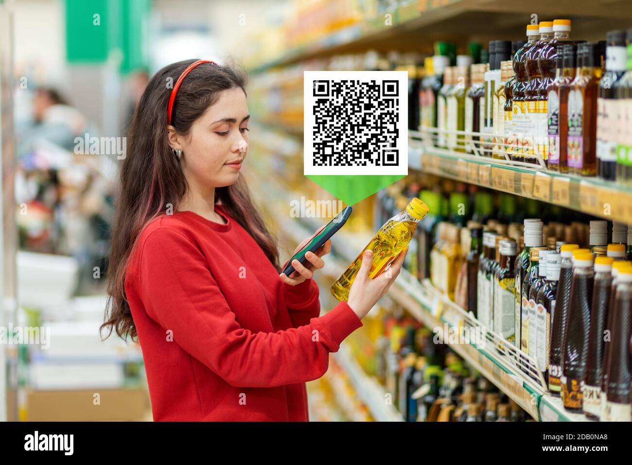 A young Caucasian woman scans the qr code on an oil bottle using her ...