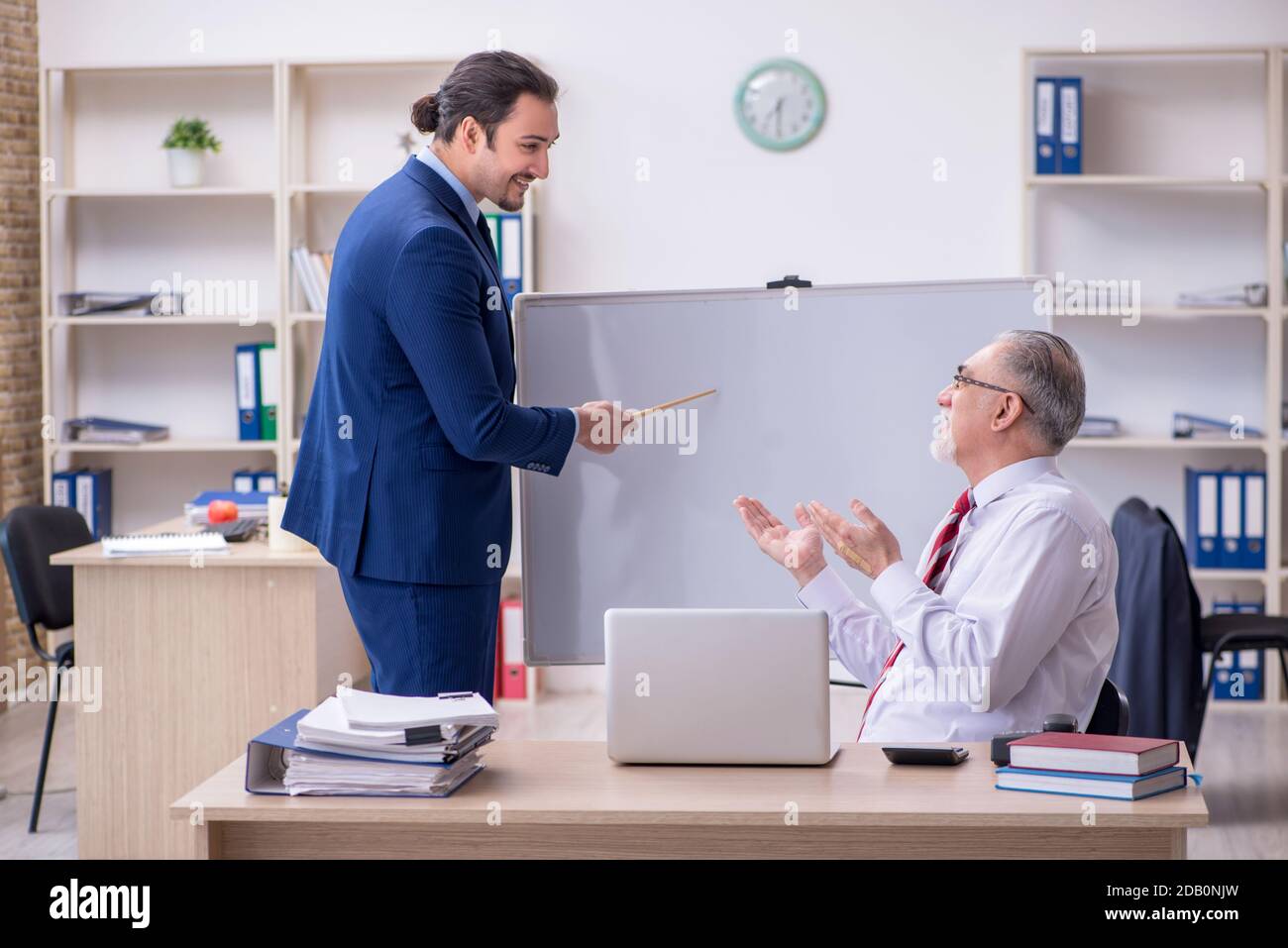 Two employees in the office at business presentation Stock Photo - Alamy