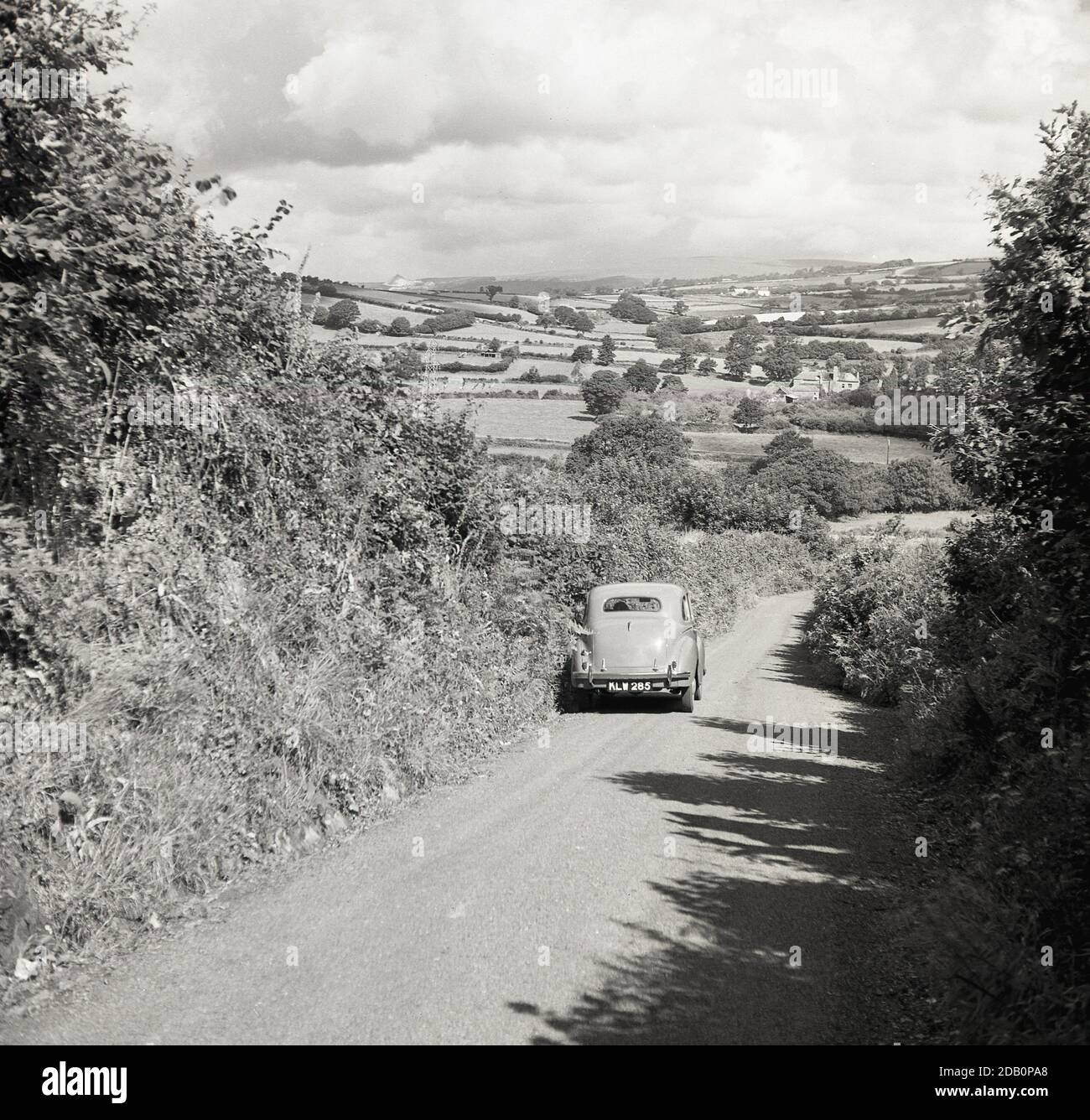 1950s, historical, a motorcar of the era parked in a country lane near ...