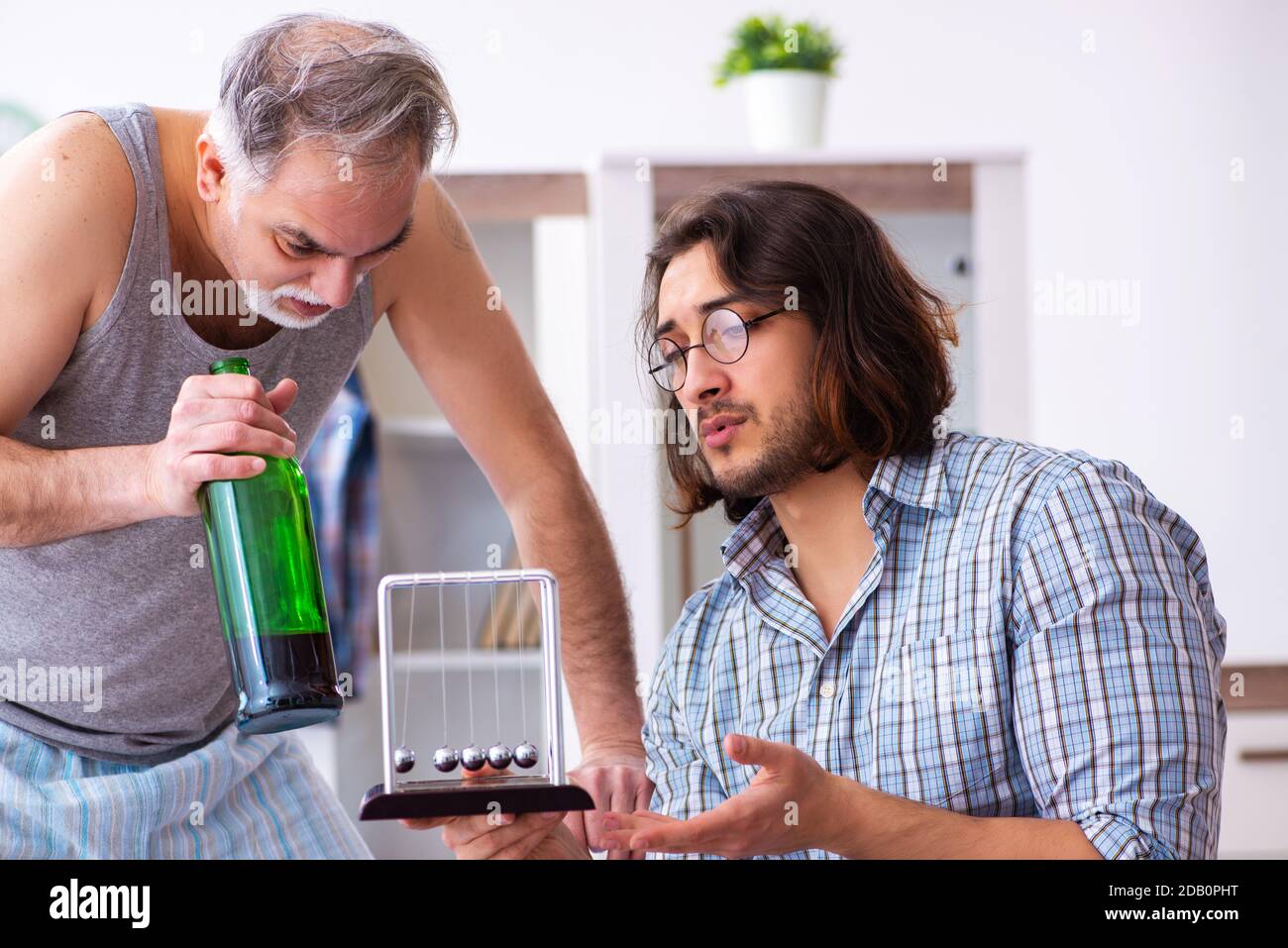 Young son student and dad alcoholic at home Stock Photo - Alamy