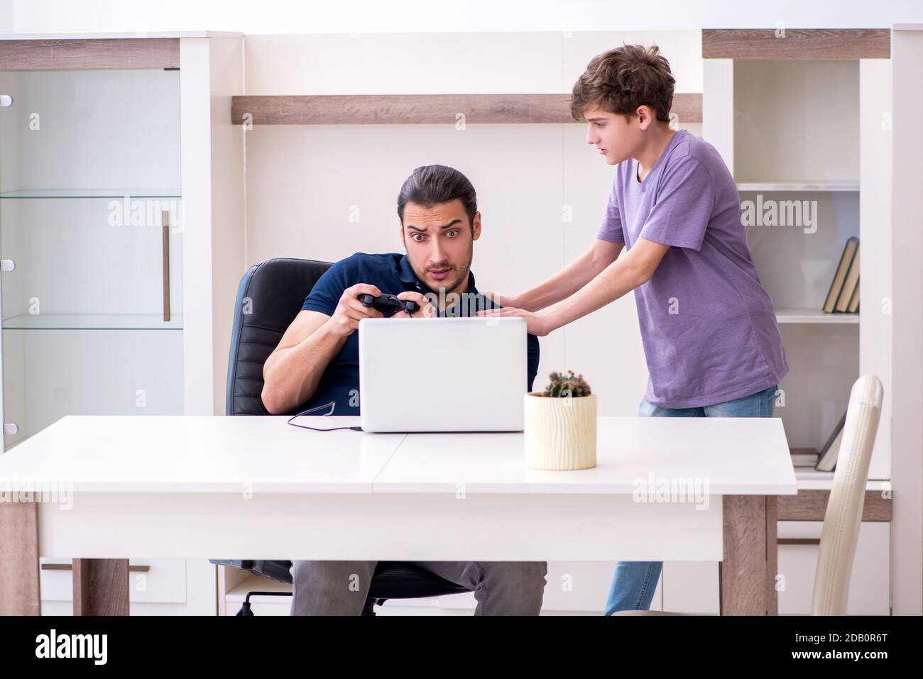 Father and schoolboy playing computer games at home Stock Photo - Alamy