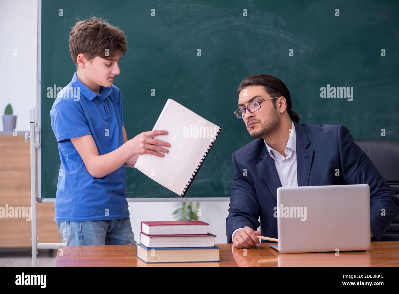 Male teacher and schoolboy in the classroom Stock Photo - Alamy