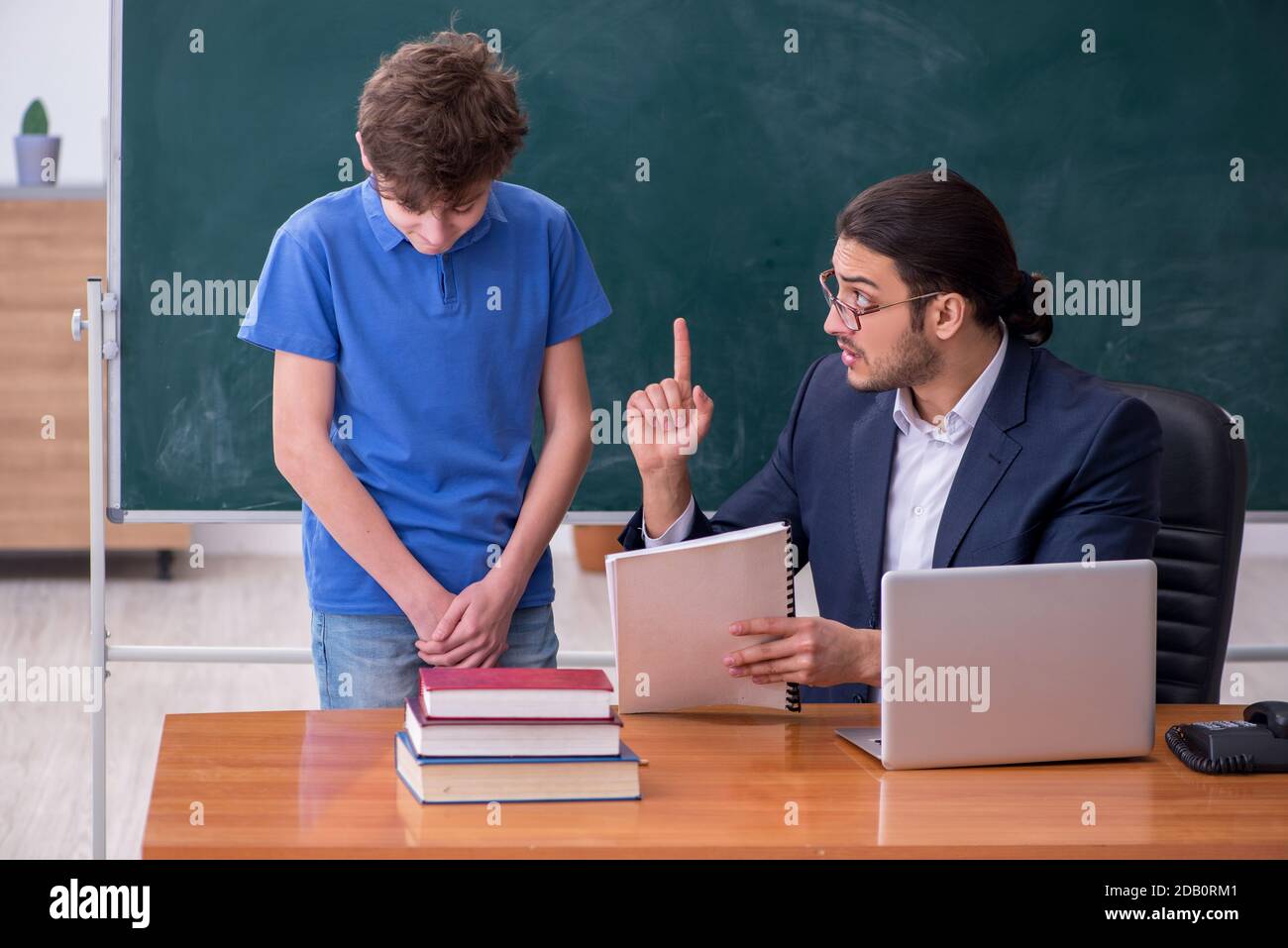 Male teacher and schoolboy in the classroom Stock Photo - Alamy