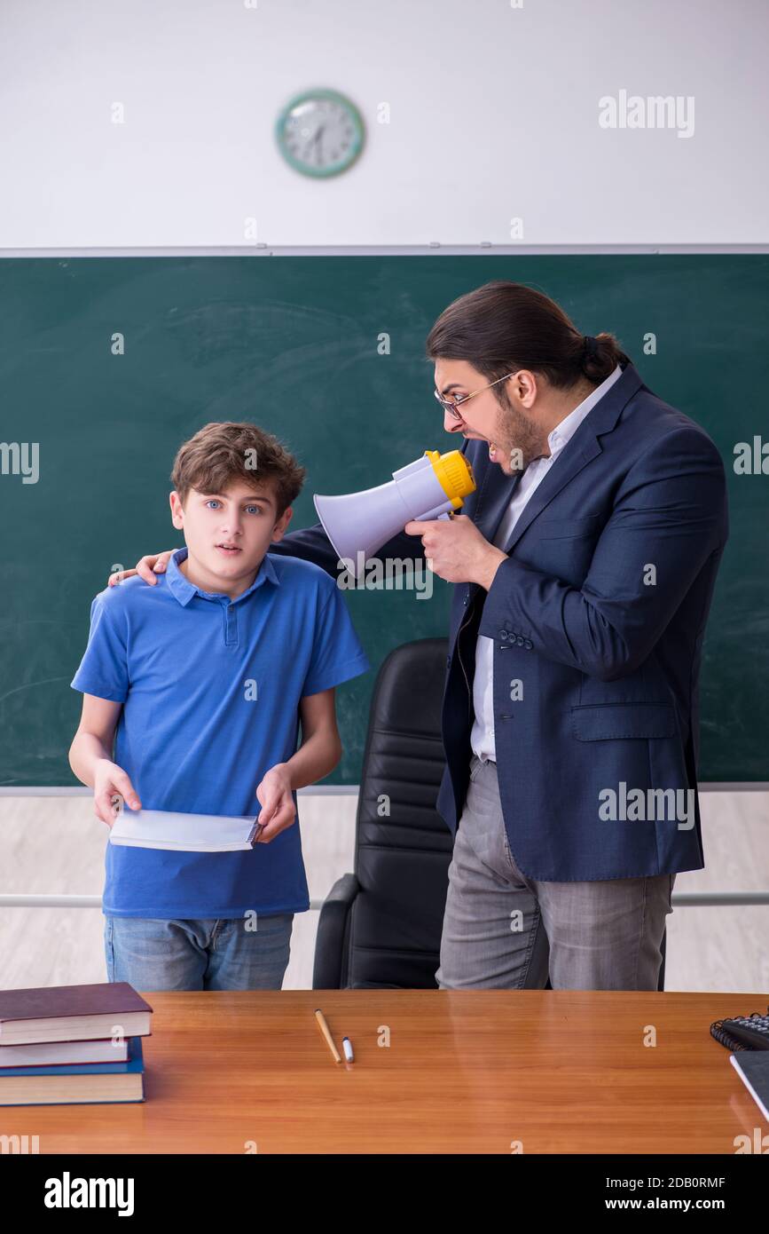 Male teacher and schoolboy in the classroom Stock Photo - Alamy